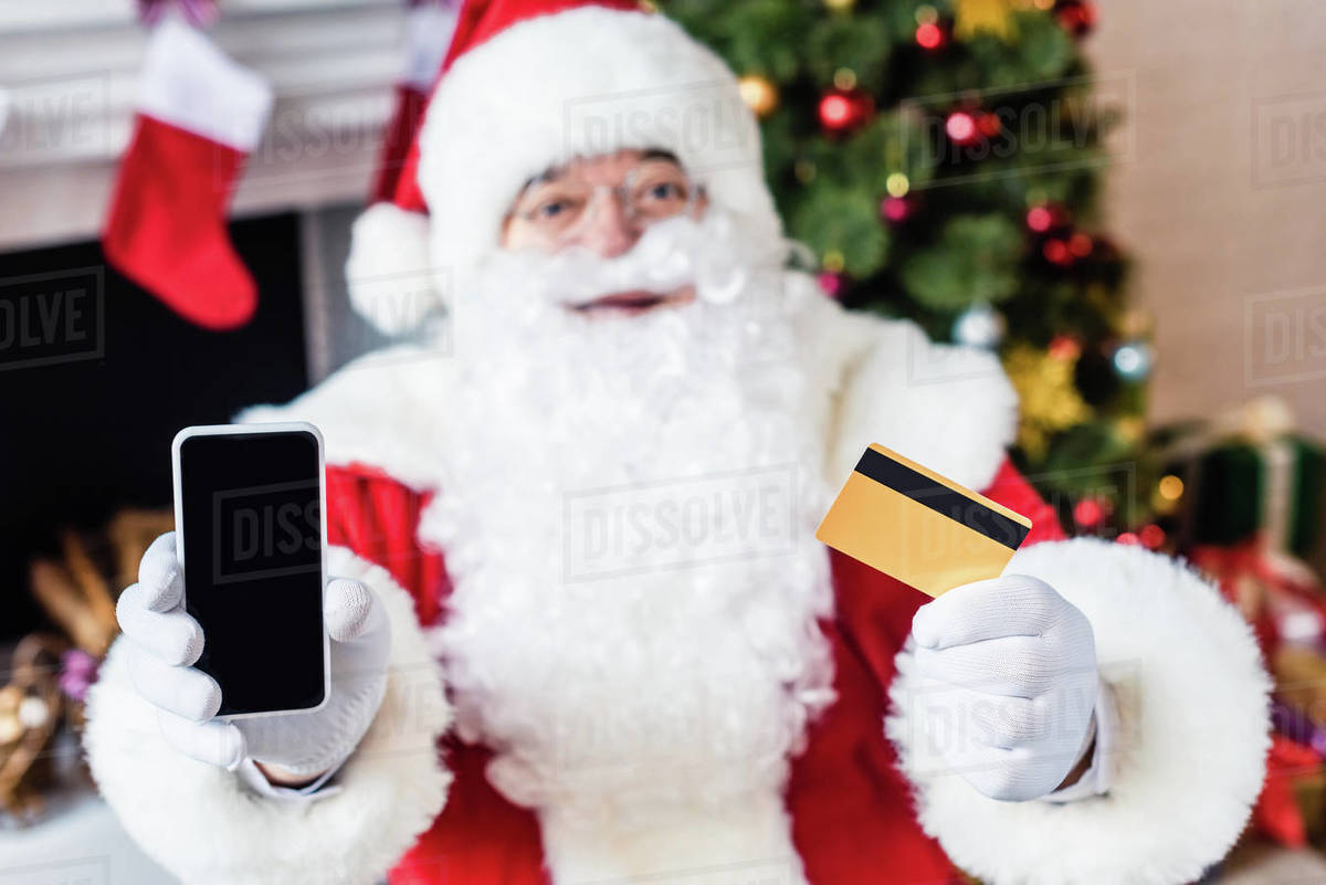 Santa Claus holding credit card and showing smartphone with blank ...