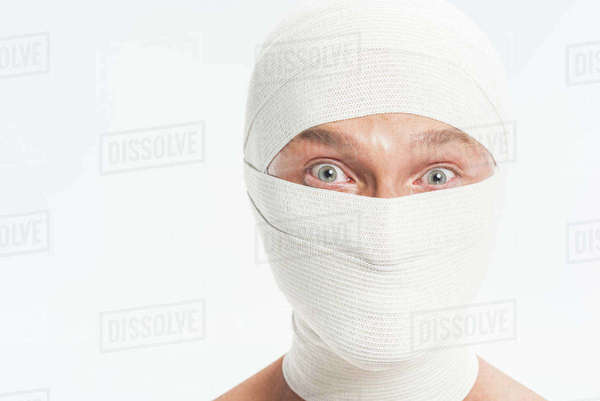 Close up of man face covered with white bandages after plastic surgery ...