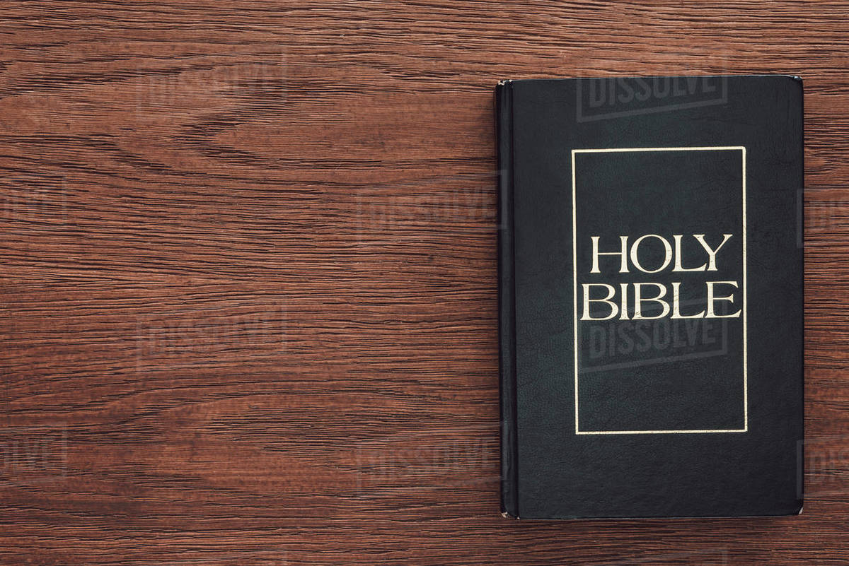 Top view of closed holy bible lying on wooden surface - Royalty-free ...
