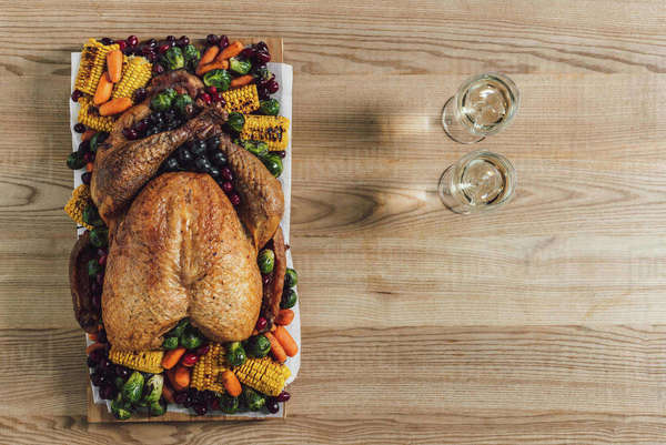 Top view of roasted turkey, vegetables and glasses of wine for ...