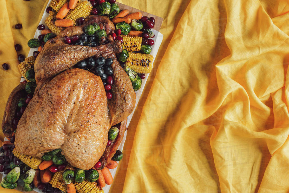 Top view of roasted festive turkey and vegetables on tabletop with ...