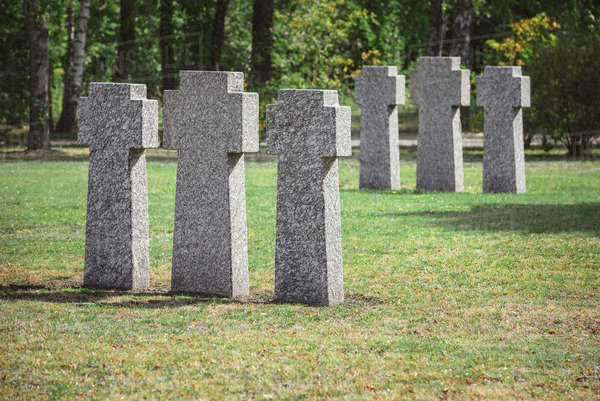 selective focus of identical gravestones placed in rows at graveyard ...
