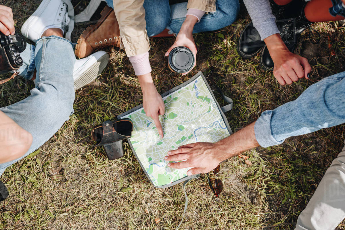 Overhead view of travelers looking for destination on map - Stock Photo ...