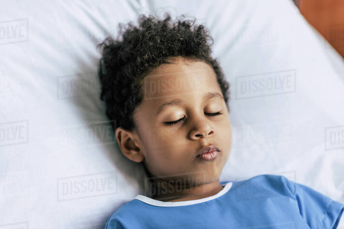 Portrait of preteen African American boy sleeping in bed - Royalty-free ...