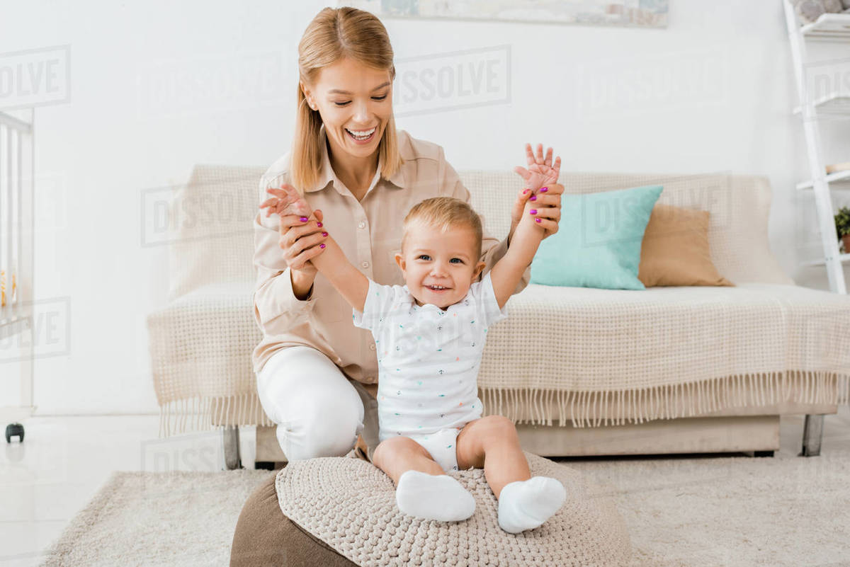 Adorable toddler raising hands up with mother in nursery room - Royalty ...