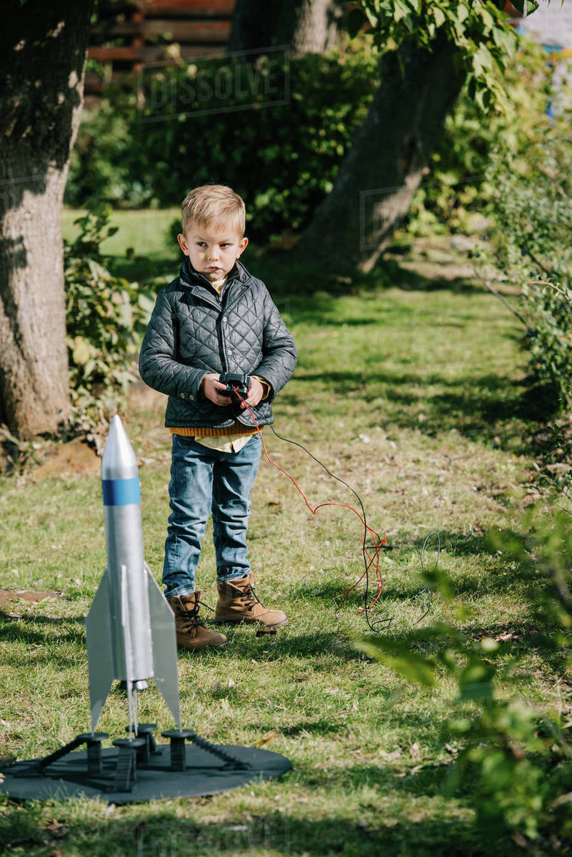 Cute little boy launching model rocket outdoor - Stock Photo - Dissolve