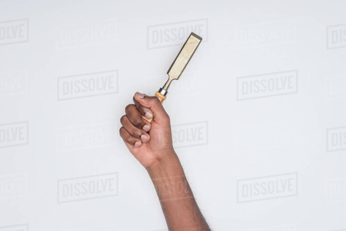 cropped shot of african american man holding chisel isolated on white ...