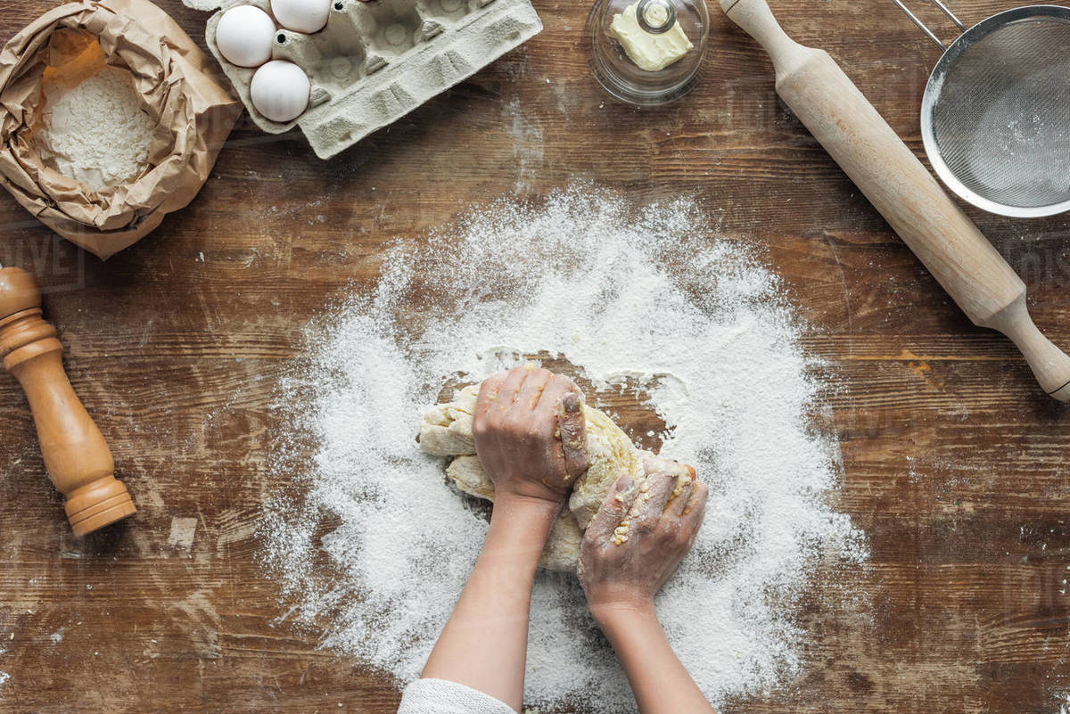 top view of female hands making dough on wooden table - Royalty-free ...