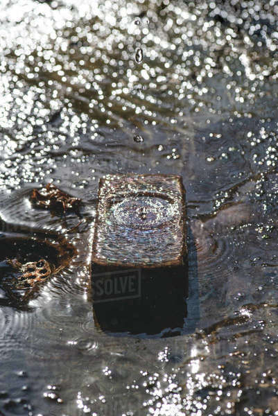 water dripping on brick in river, sun reflecting on surface - Royalty ...