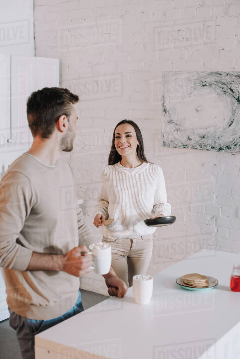 Beautiful young couple making breakfast together at home - Stock Photo ...
