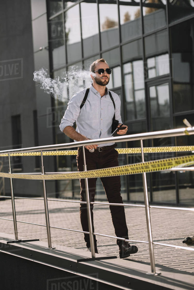 Smoking male detective walk through the crime scene - Royalty-free ...