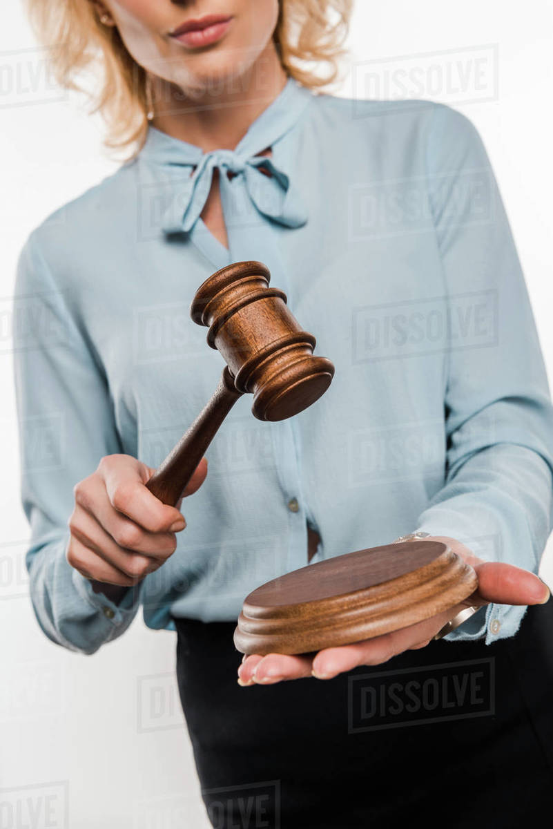 Cropped shot of female judge holding wooden hammer isolated on white ...