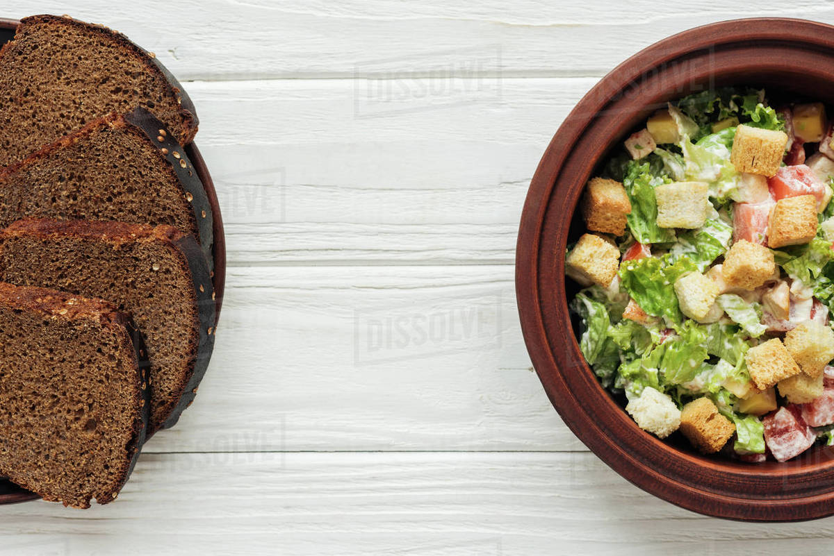 Top view of delicious traditional Caesar salad with croutons in bowl ...