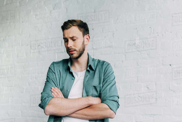 Selective focus of upset man standing with crossed arms - Royalty-free ...