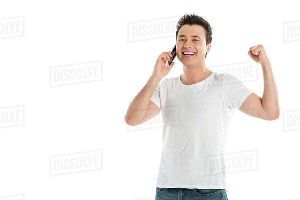 Excited handsome man talking on smartphone and cheering isolated on ...