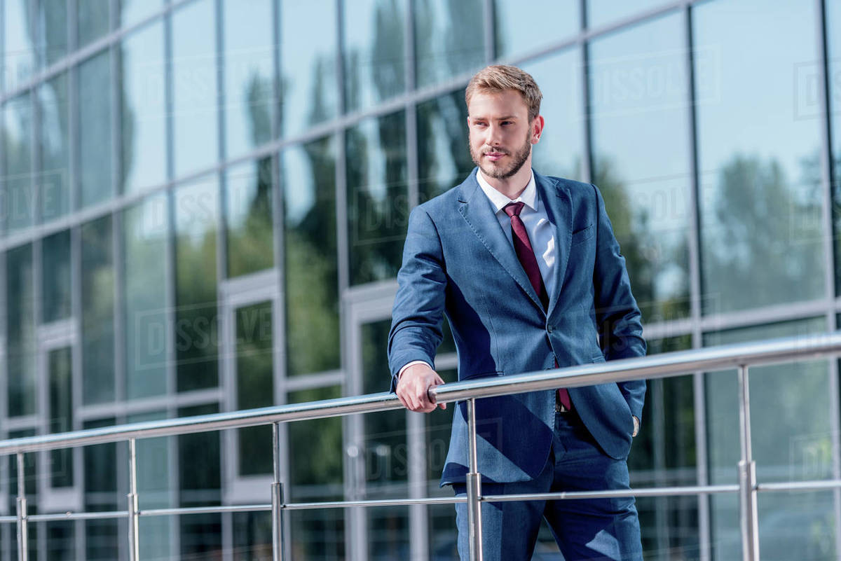 stylish businessman in suit standing at office building - Royalty-free ...