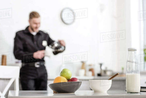 milk bottle, bowl of fruits on kitchen table and police officer at ...