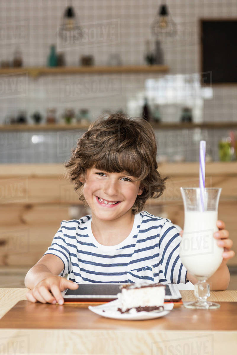 Cute little boy with digital tablet and milkshake in cafe - Royalty ...