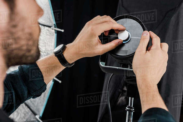 Cropped shot of young man working with professional lighting equipment ...