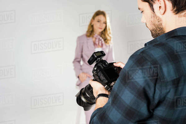 Cropped shot of photographer using camera and model posing in photo ...