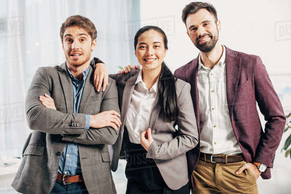 Happy office managers looking at camera and smiling in office - Royalty ...