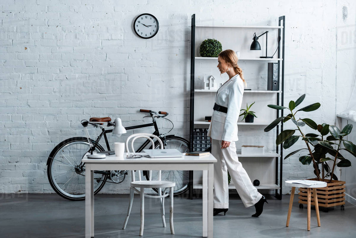Businesswoman in white formal wear in modern office interior - Stock ...