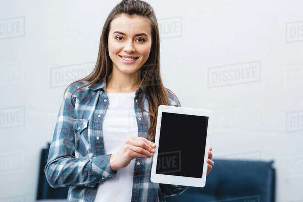 Happy girl holding digital tablet with blank screen and smiling at ...