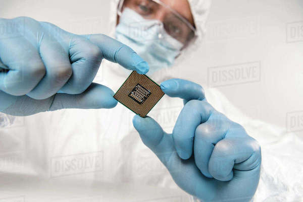 Selective focus of microchip in hands of scientist wearing latex gloves ...