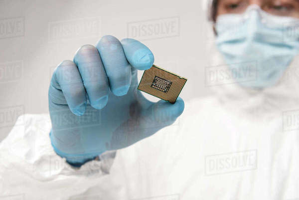 Selective focus of microchip in hand of scientist wearing latex glove ...