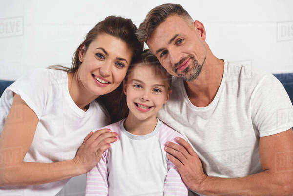 Happy smiling parents hugging daughter in pajamas - Royalty-free Stock ...