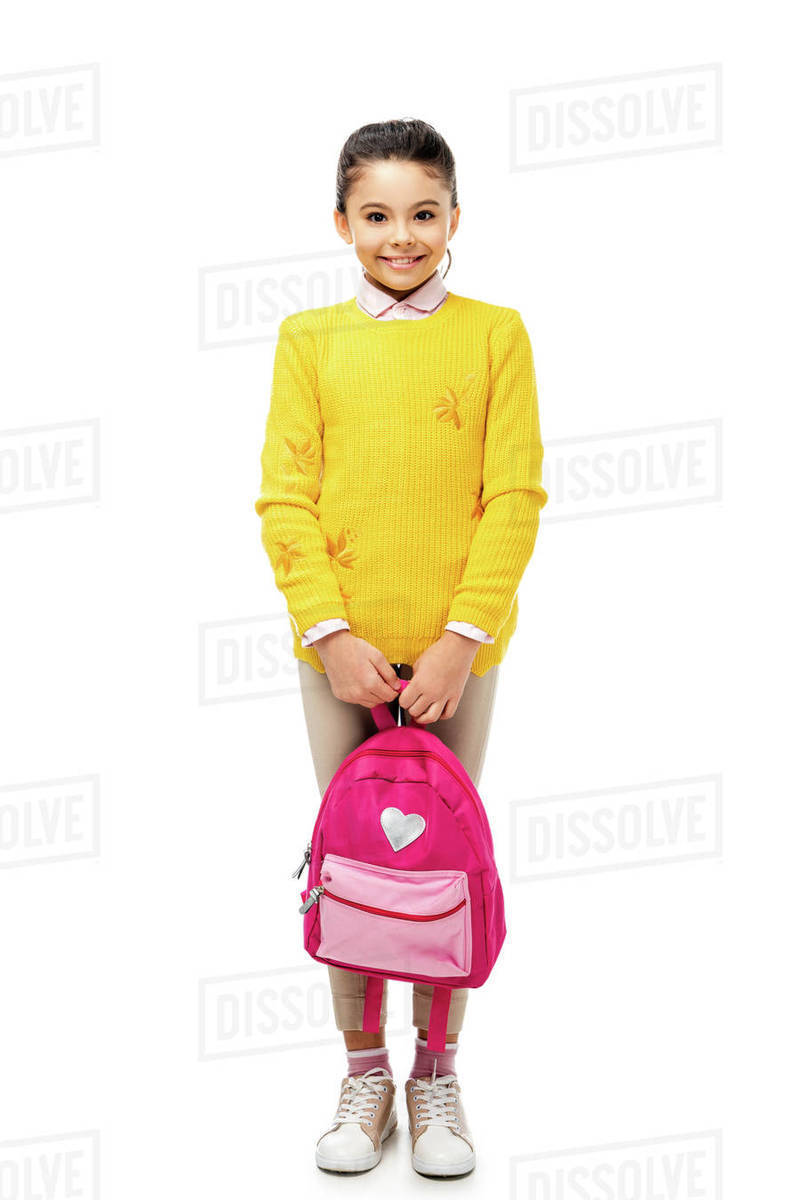 Adorable child holding backpack and smiling at camera isolated on white ...