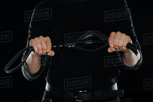 Cropped view of female hands tightly holding leather flogging whip ...