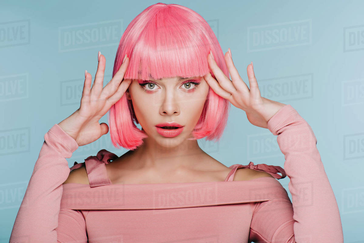 Attractive shocked girl gesturing and posing in pink wig isolated on ...