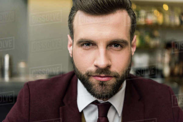 Portrait of handsome focused businessman in formal wear looking at ...
