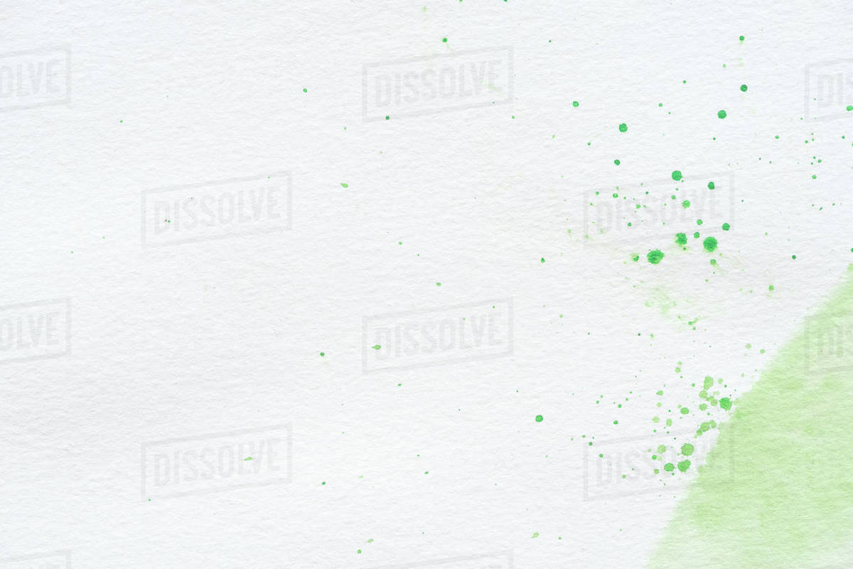 Abstract green watercolor splatters on white paper background with copy ...