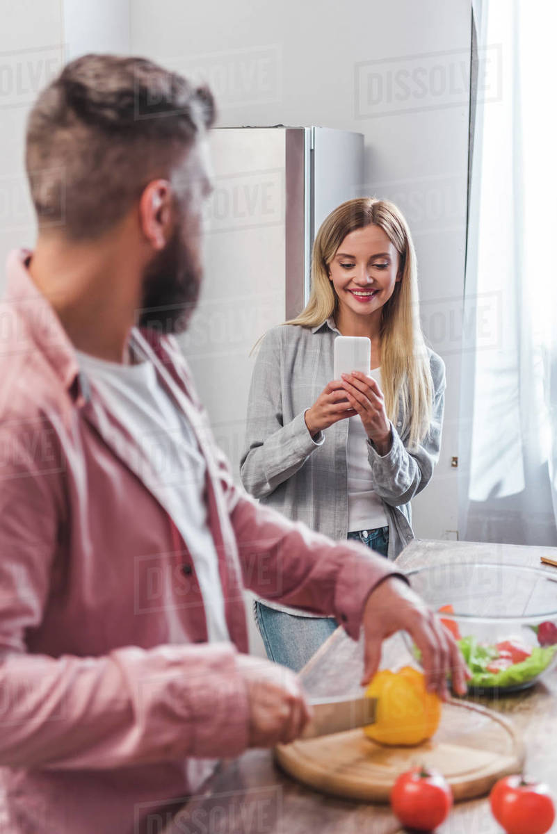 Beautiful wife taking photo of husband on smartphone - Stock Photo ...