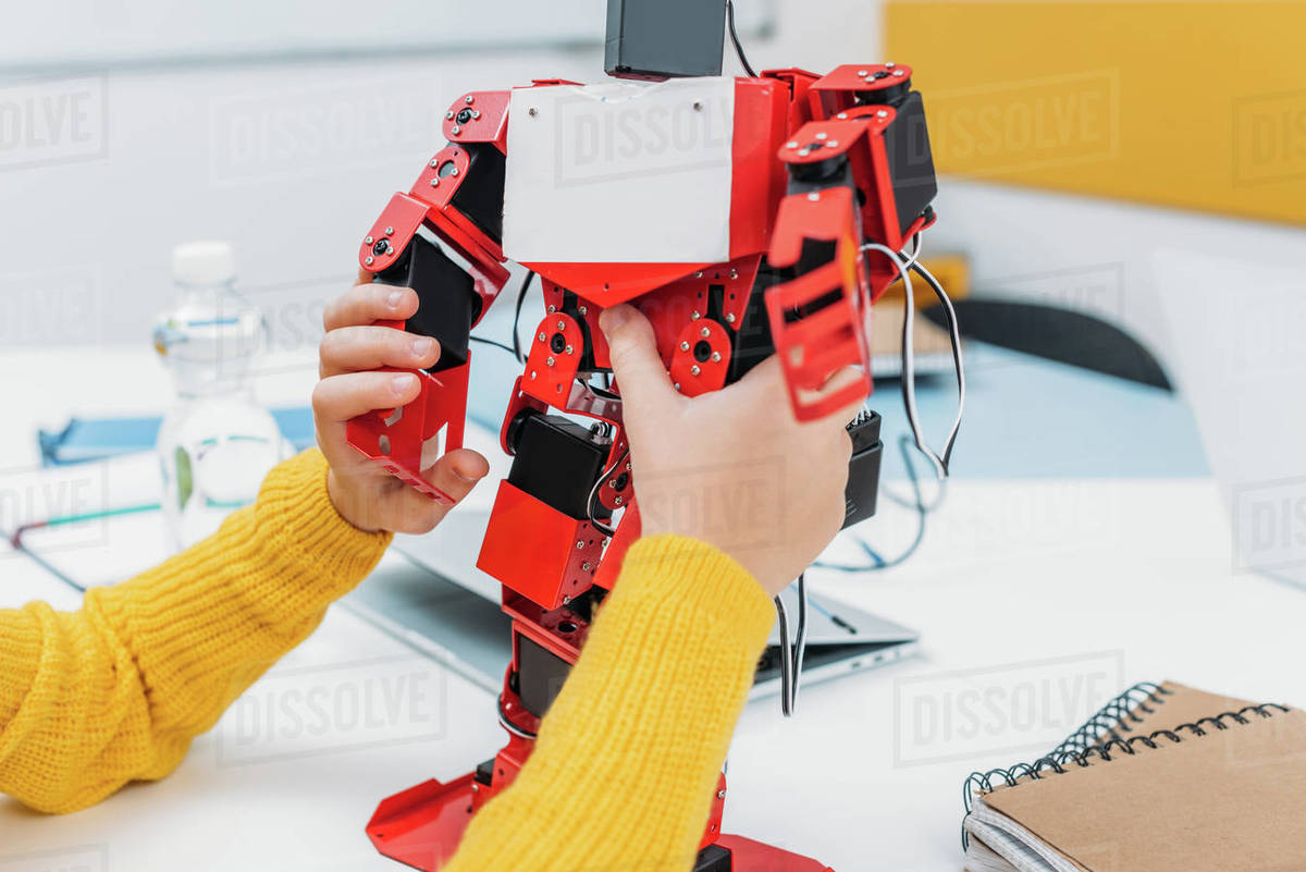 Cropped view of schoolkid playing with robot model at stem educational ...
