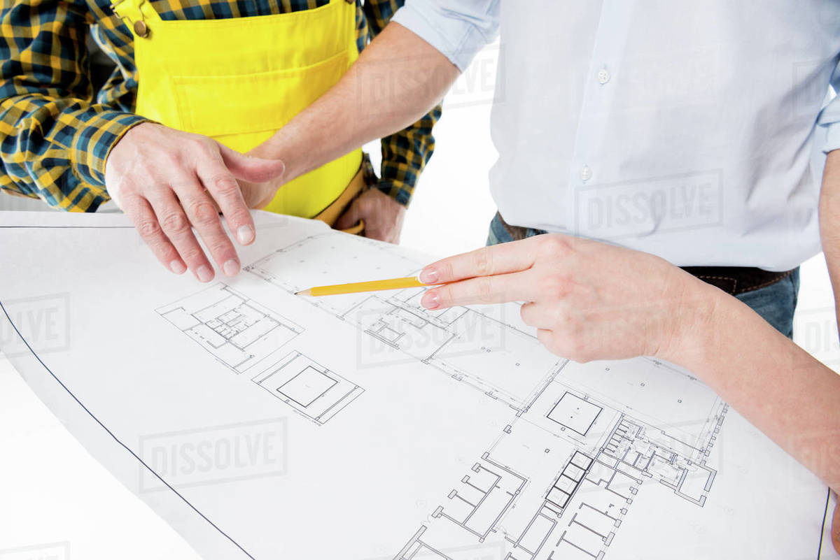 Partial view of architects examining blueprint together isolated on ...