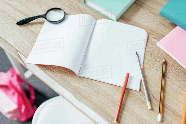 Writing desk with school supplies and open notebook placed on it ...