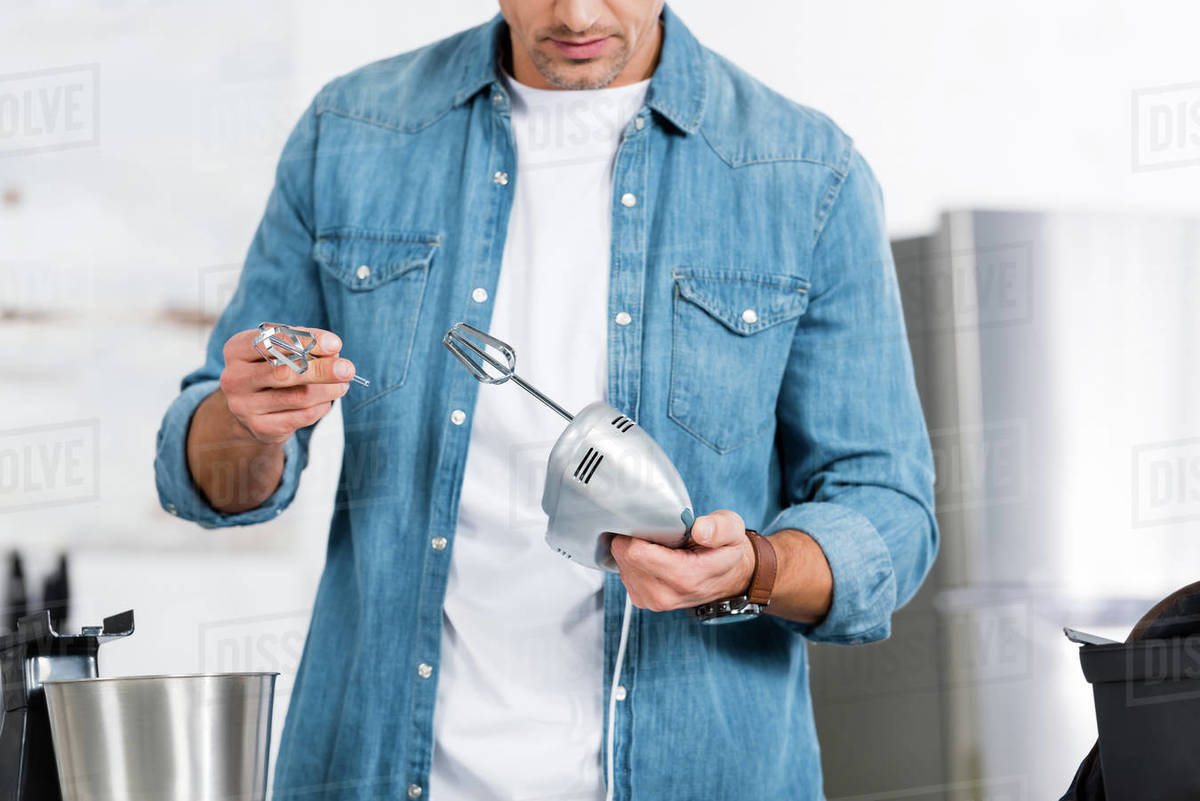 Cropped view of man holding kitchen mixer and whisk - Royalty-free ...