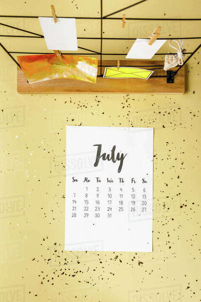 Top view of July calendar with golden confetti and cards with ...