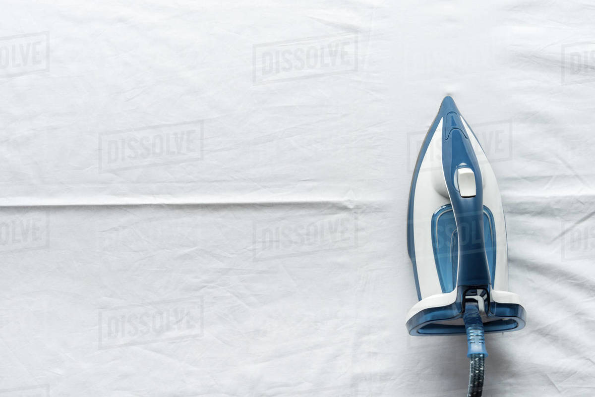 Top view of electrical iron standing on white bed sheets - Stock Photo ...