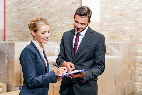 Business colleagues signing contract at warehouse - Royalty-free Stock ...