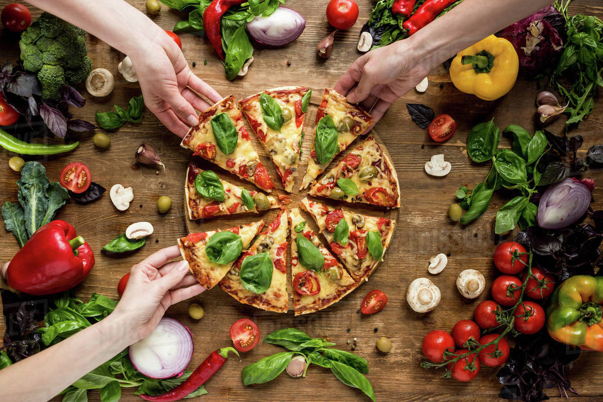 Partial view of friends taking homemade pizza slices - Stock Photo ...