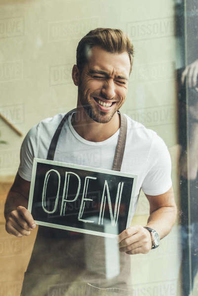 Portrait of smiling waiter holding chalkboard with open word - Stock ...