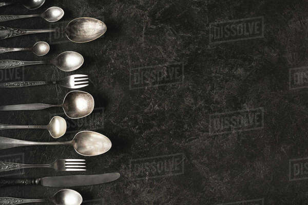 Top view of set of vintage silverware isolated on black table - Royalty ...