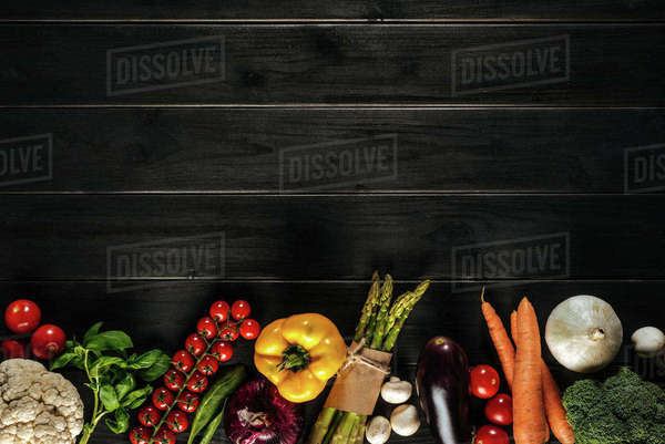 Different fresh vegetables lying in row on wooden tabletop with copy ...