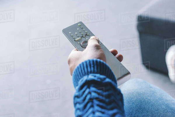Cropped shot of man holding tv remote - Royalty-free Stock Photo | Dissolve