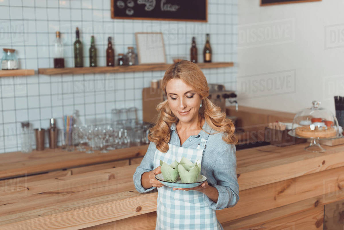 beautiful smiling waitress holding plate with dessert in cafe - Stock ...