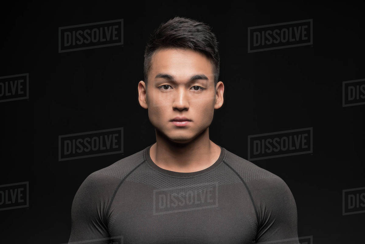 Portrait of handsome young Asian man looking at camera isolated on ...
